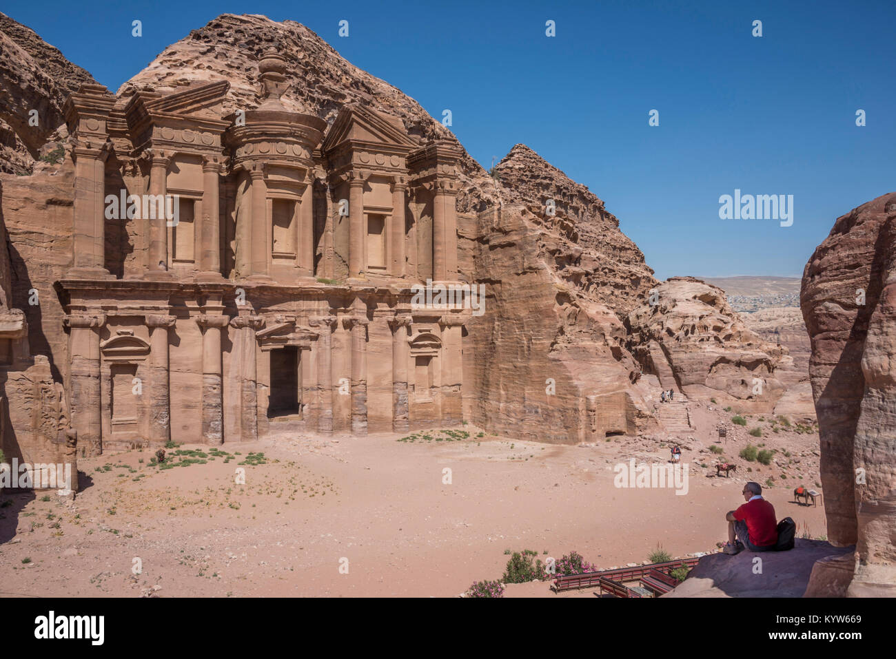 A tourist sitting in the shadow of a rock, observes the Monastery of ...
