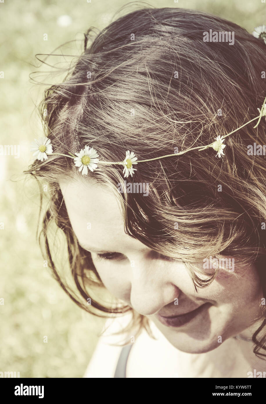 Woman wearing a daisy chain on hair, looking down Stock Photo - Alamy