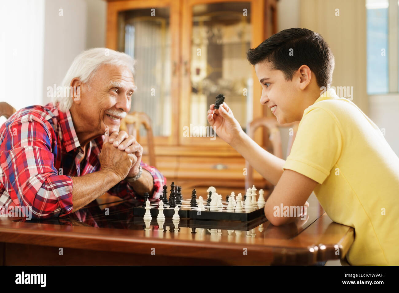 Grandpa Playing Chess Board Game With Grandson At Home Stock Photo - Alamy