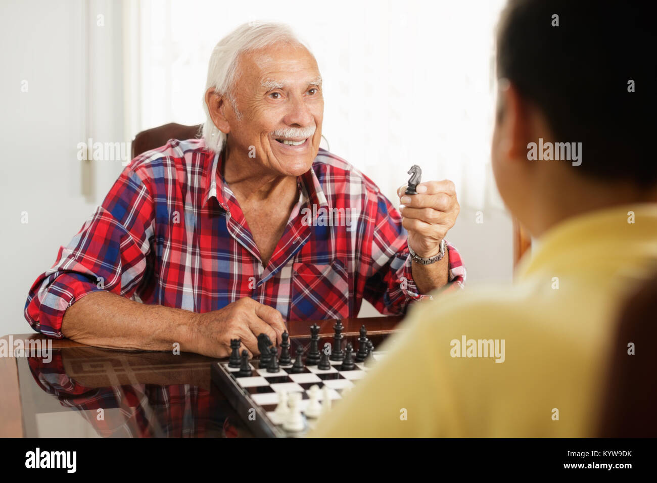 Grandpa Playing Chess Board Game With Grandson At Home Stock Photo - Alamy
