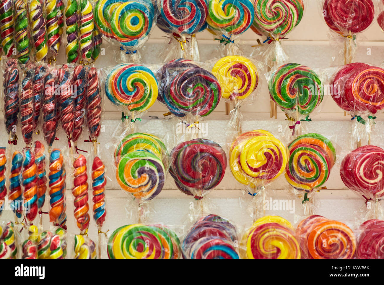 Rows of colorful spiral and rainbow-swirl lollipops on display on the ...