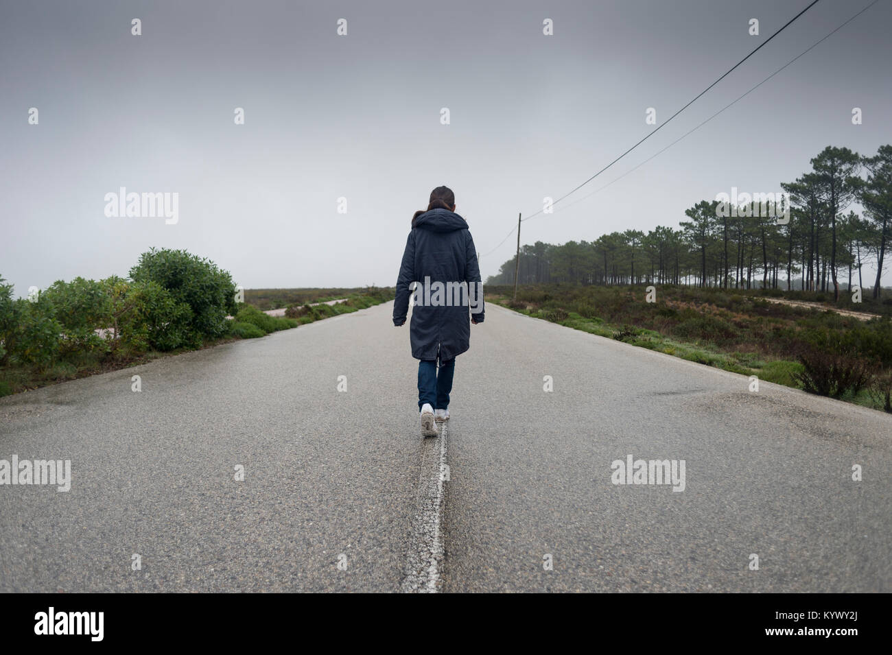 Woman walking along road in hi-res stock photography and images - Alamy