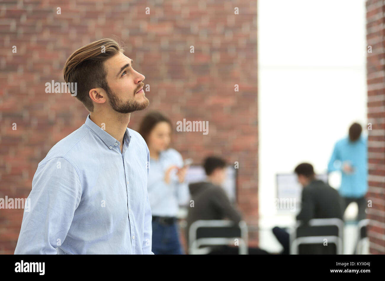 Young businessman looking away while working in the office Stock Photo ...