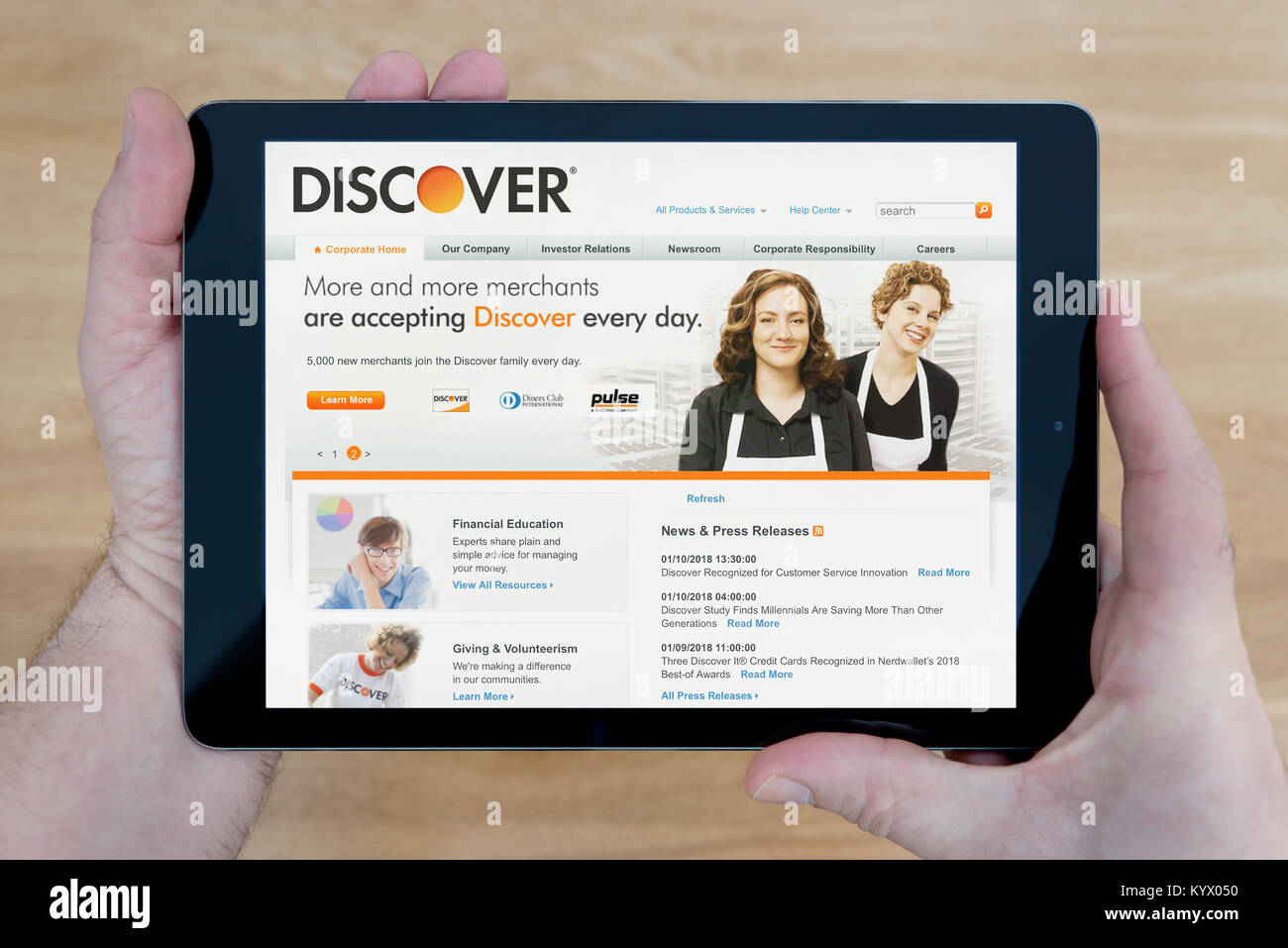 A man looks at the Discover Bank website on his iPad tablet device ...