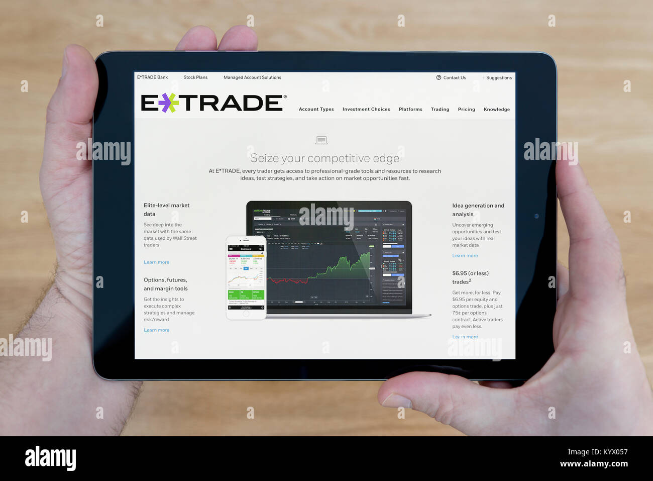 A man looks at the E-Trade website on his iPad tablet device, with a ...