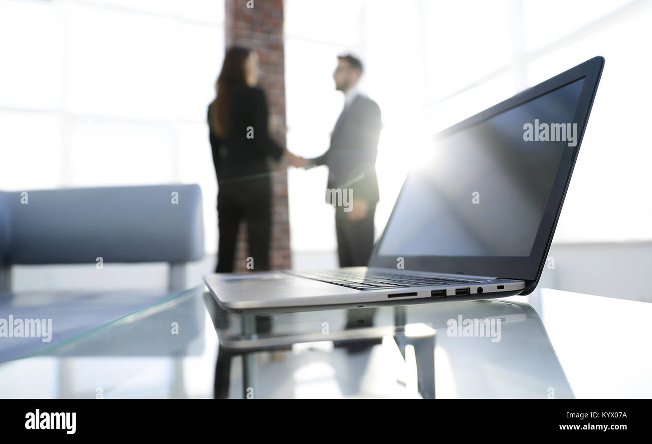 laptop on the desk, background handshake Stock Photo - Alamy