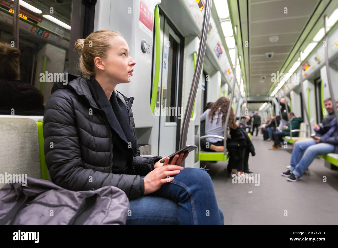 Young girl with mobile phone traveling on metro Stock Photo - Alamy