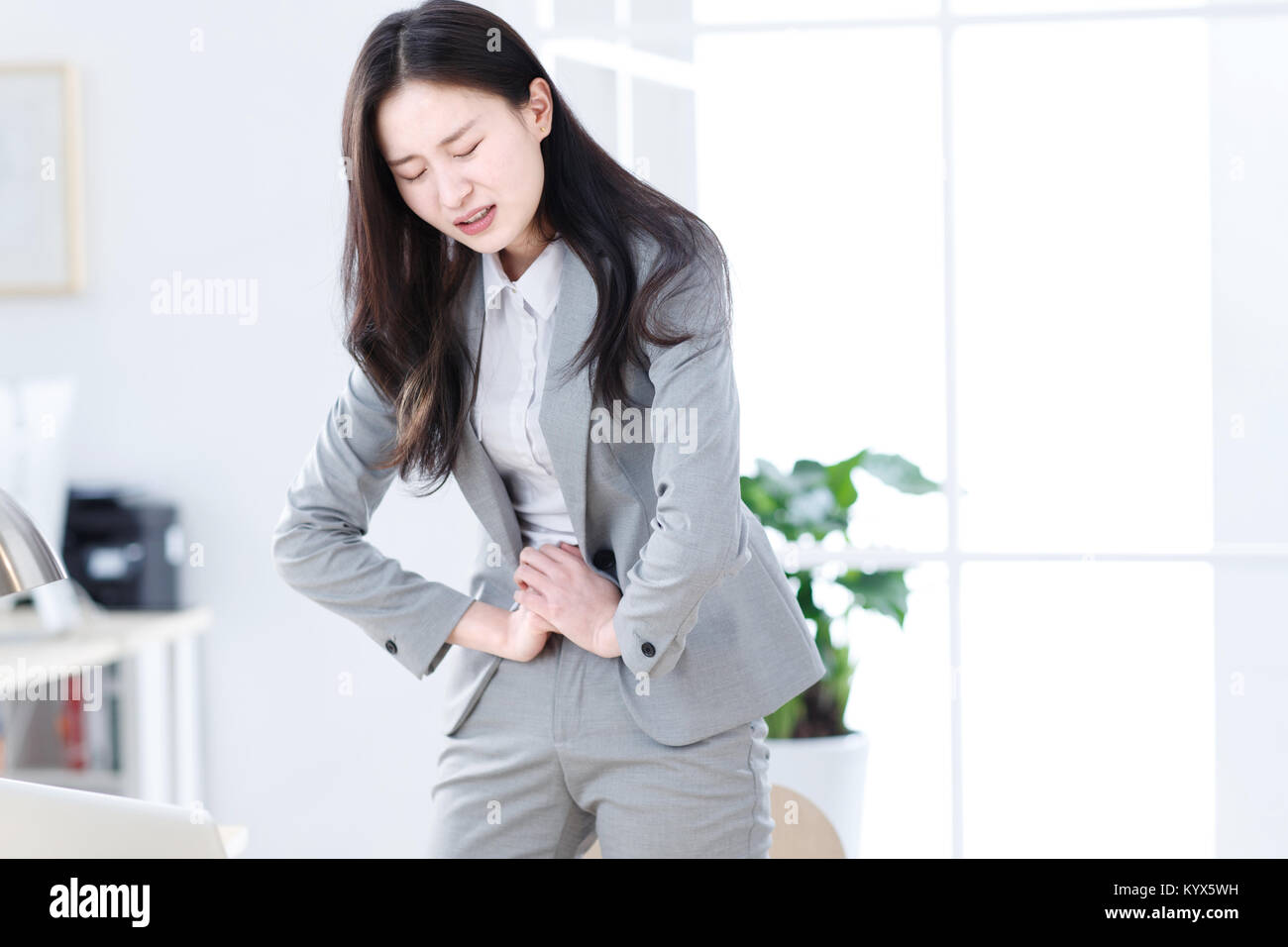 Business woman stomach pain Stock Photo - Alamy