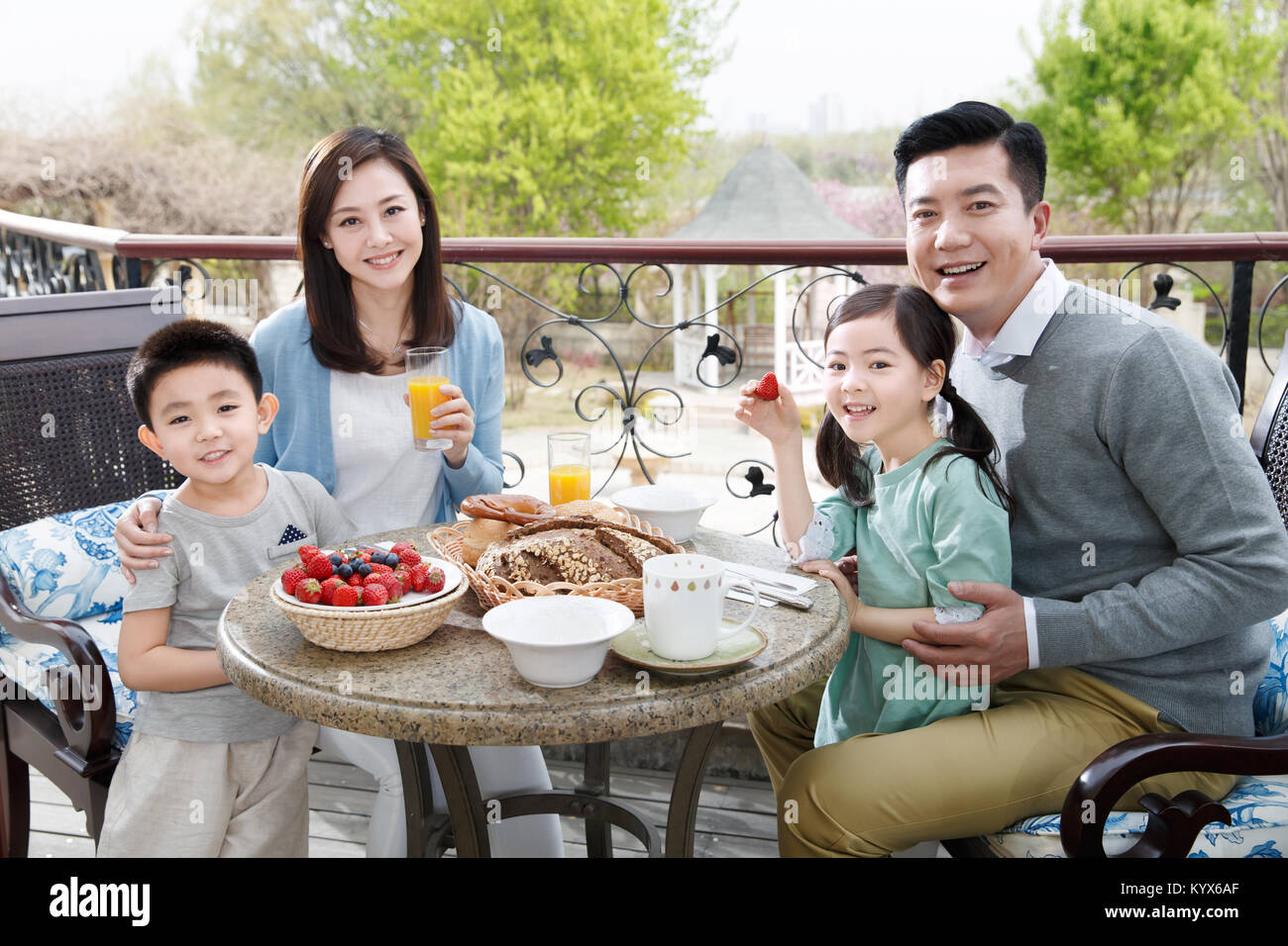 Happy families eat breakfast on the terrace Stock Photo - Alamy