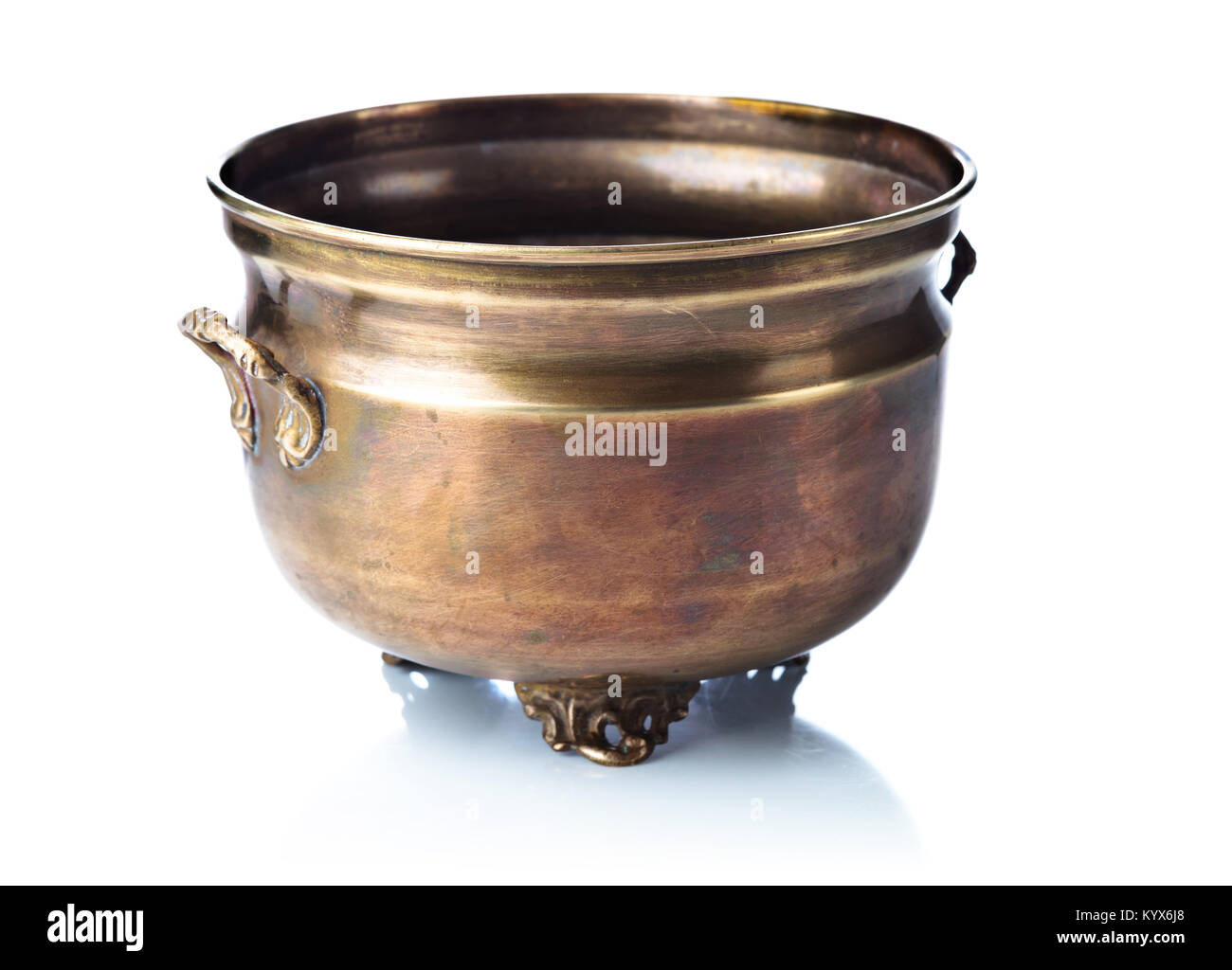 Empty old brass pot with decorative handles and legs isolated on a ...