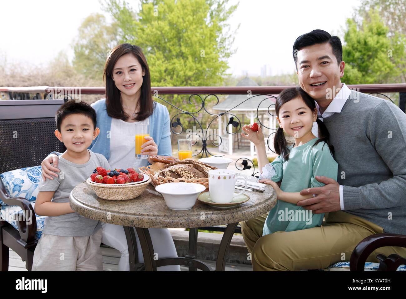Happy families eat breakfast on the terrace Stock Photo - Alamy
