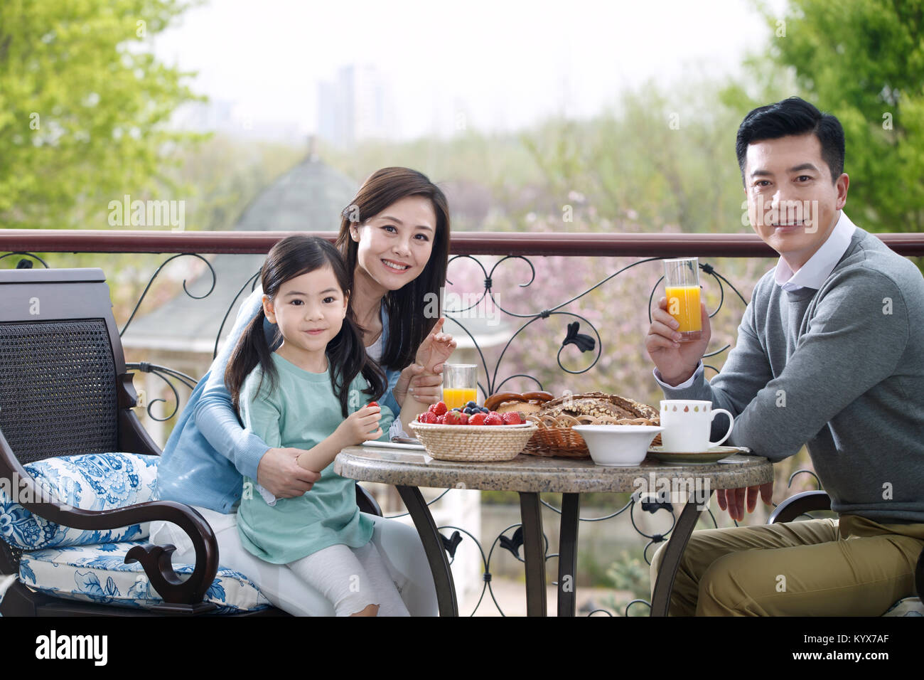 Happy families eat breakfast on the terrace Stock Photo - Alamy