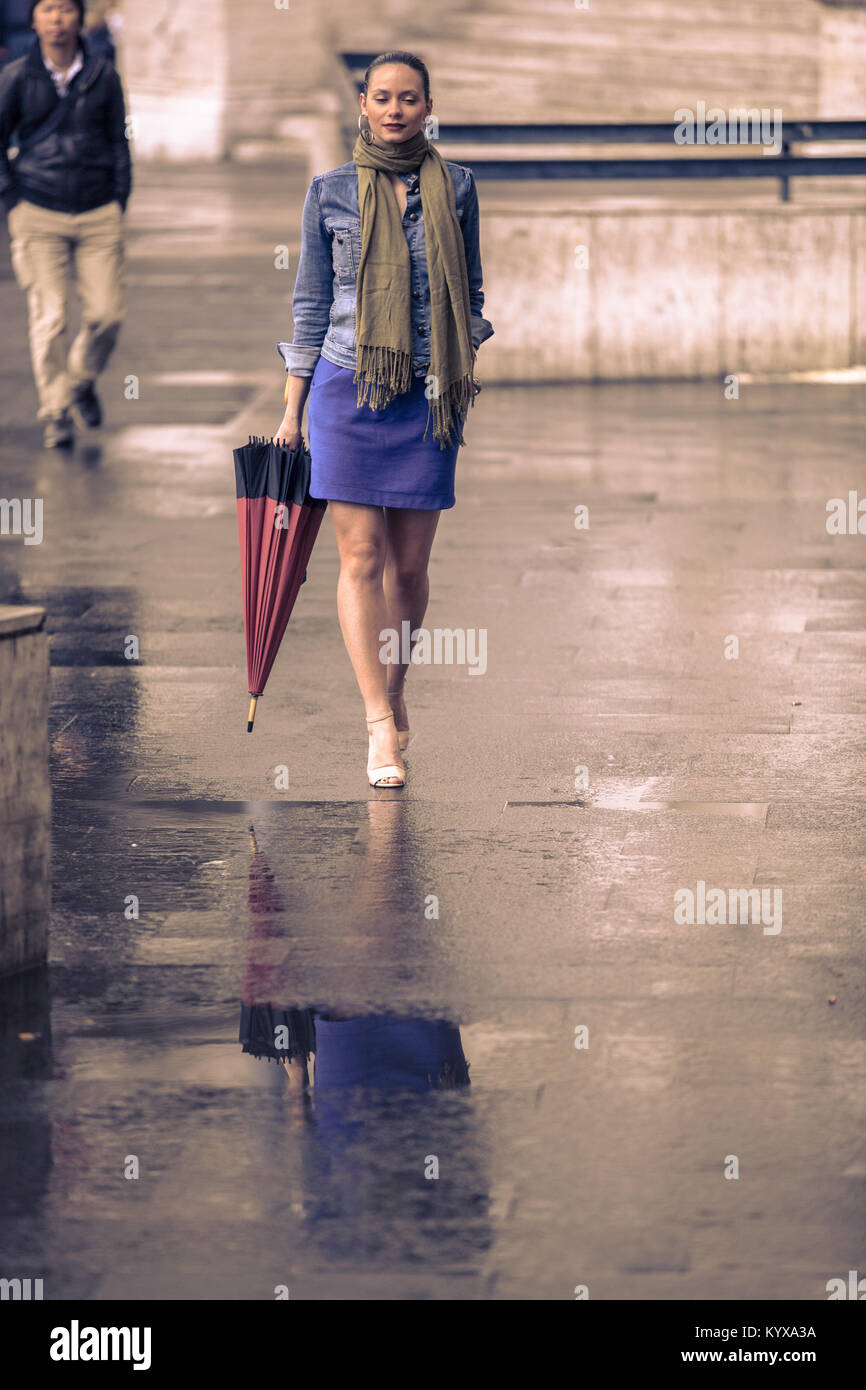 Woman with umbrella walking under the rain Stock Photo - Alamy