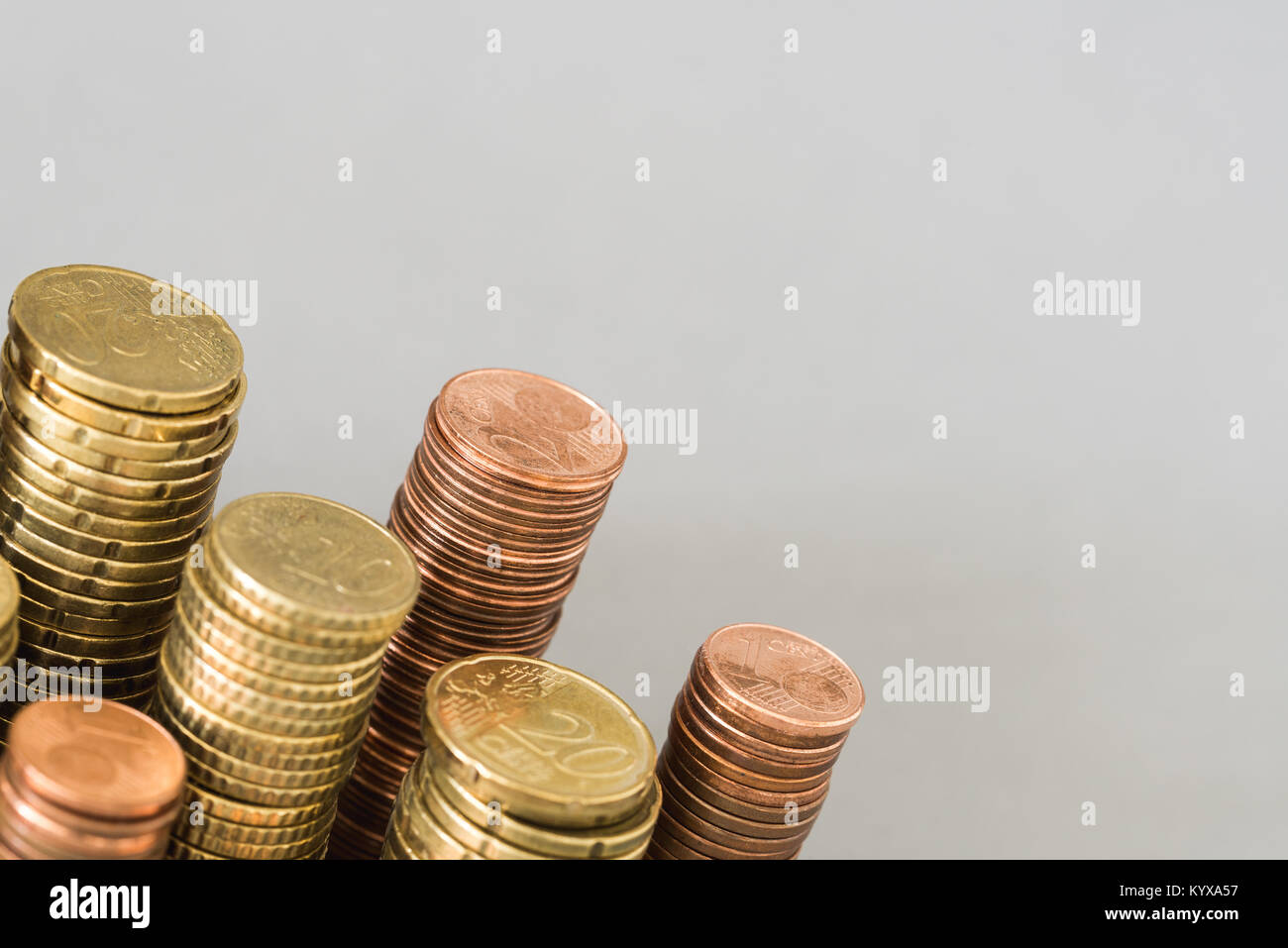 Closeup of different stacks of euro coins in front of grey background ...
