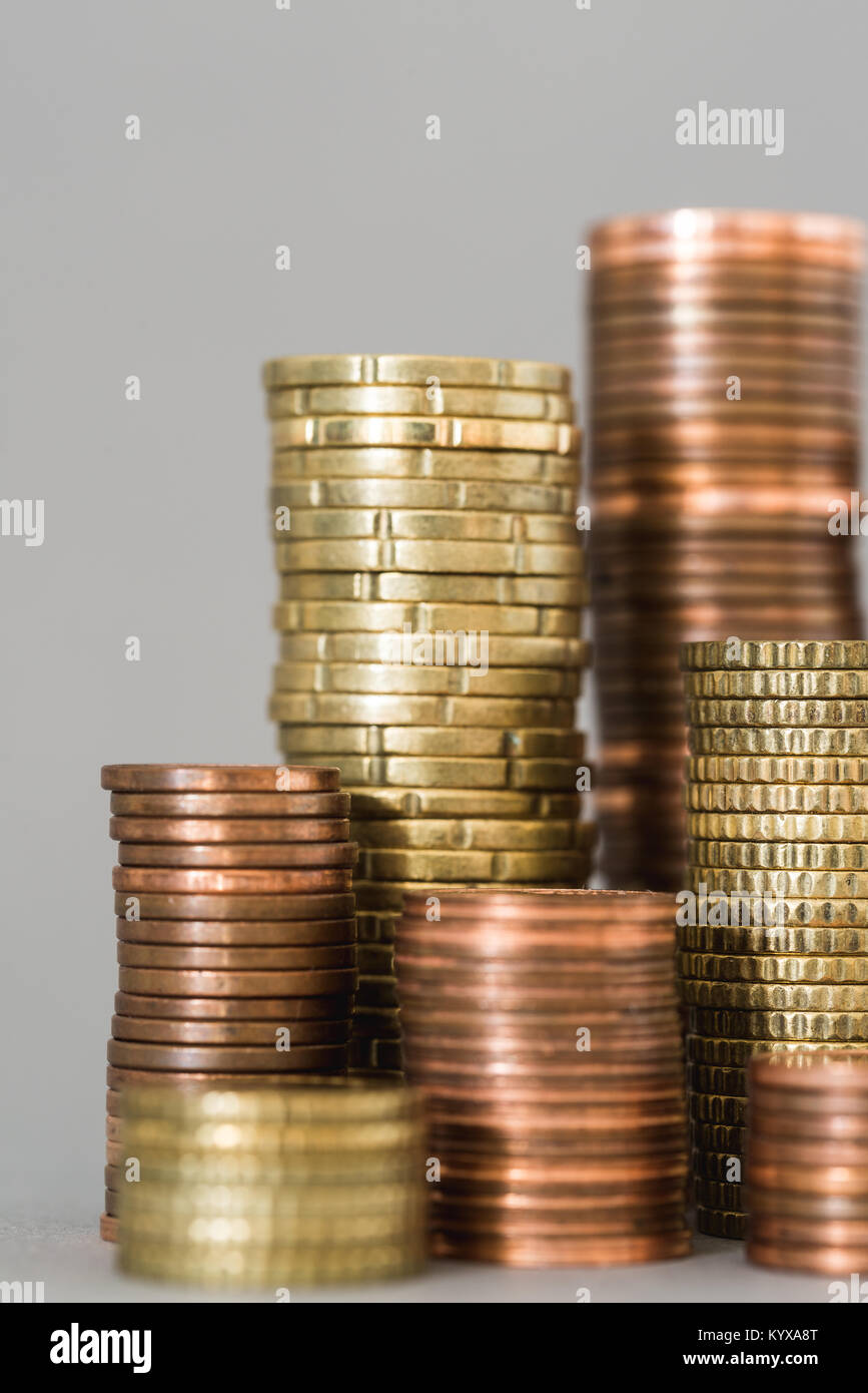 Closeup of different stacks of euro coins in front of grey background ...