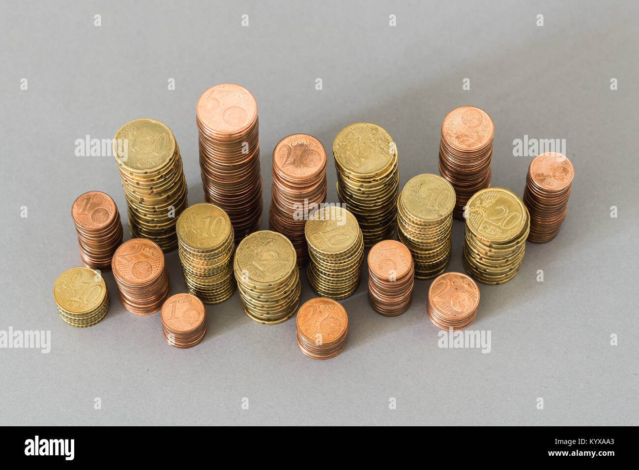 Different stacks of euro coins in front of grey background symbolizing ...
