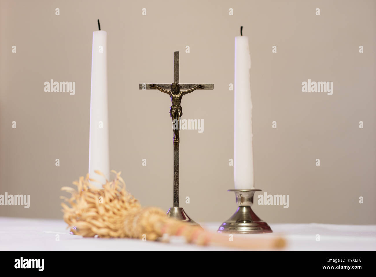 Cross and candles on a white tablecloth. Carol singing, cross and ...