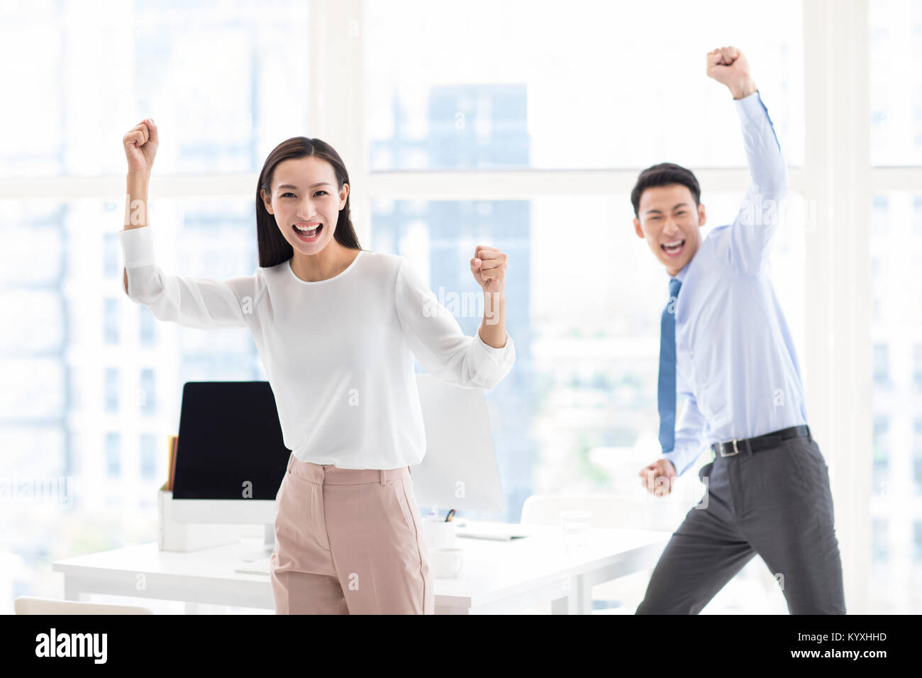 Confident business people cheering in office Stock Photo - Alamy