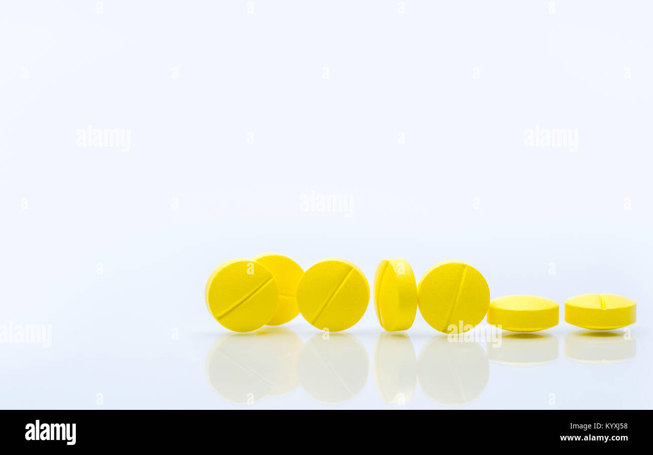 Yellow tablets pills isolated on white background with copy space. Pile ...