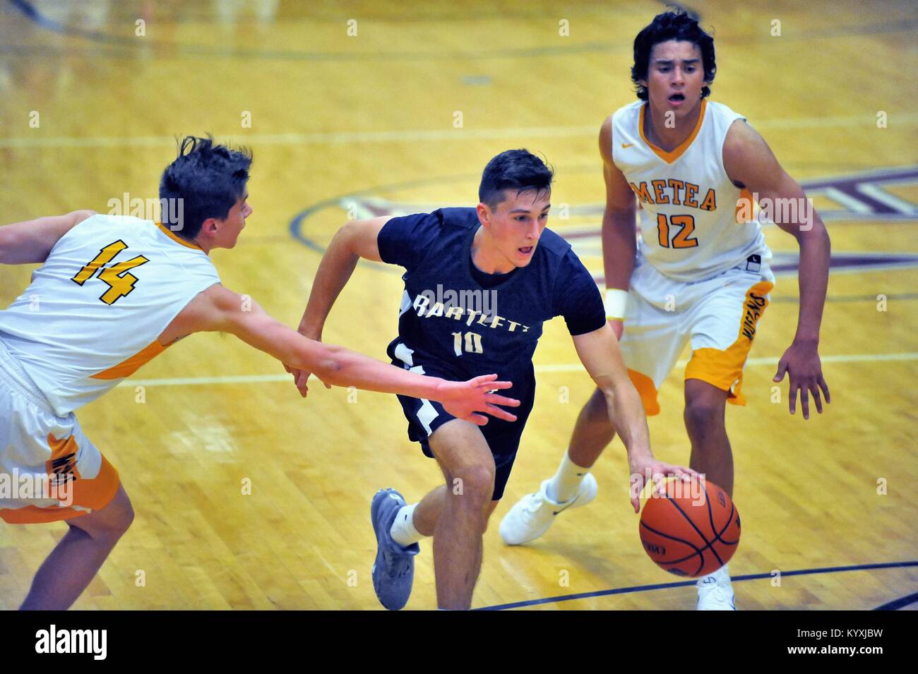 Player driving into the lane and between a pair of opponents. USA Stock ...