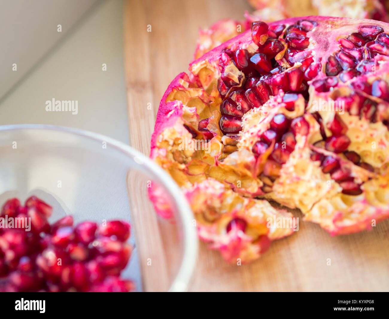 Close up to pomegranate with peel off and seeds in a glass bowl Stock ...