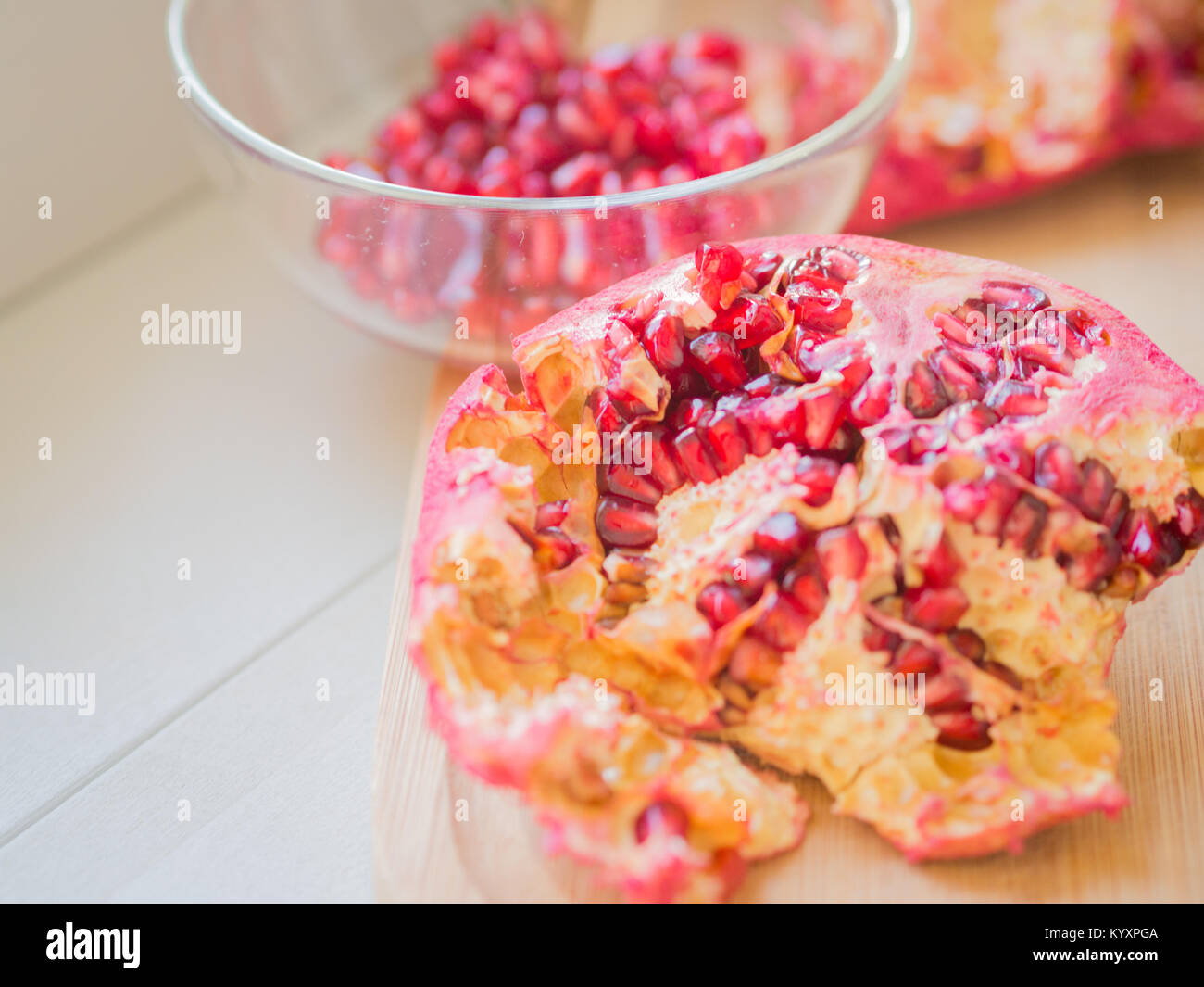 Close up to pomegranate with peel off and seeds in a glass bowl Stock ...