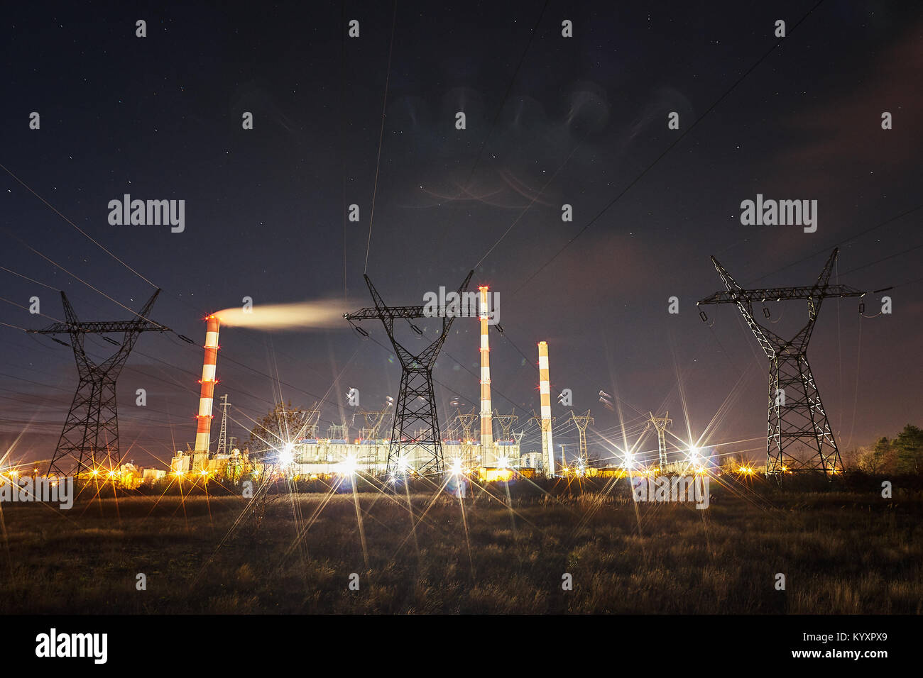 Illuminated power plant at night under a starry sky Stock Photo - Alamy