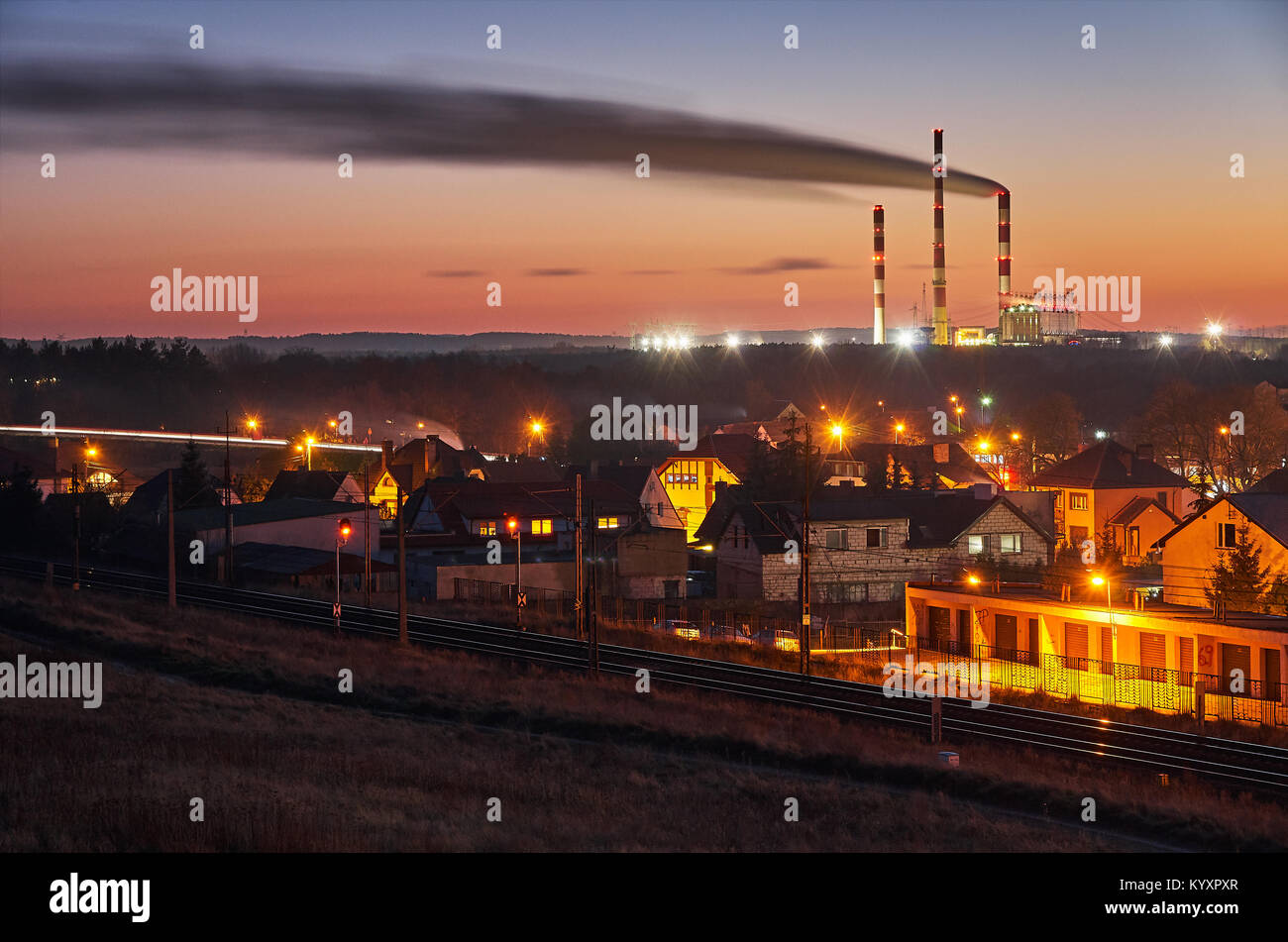 A small town and a power plant in the background after sunset Stock ...