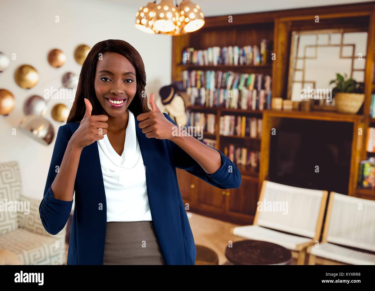 woman smiling in livingroom with thumbs up Stock Photo - Alamy