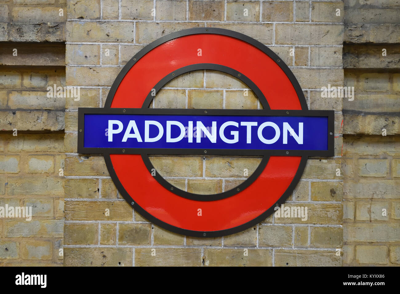 Paddington tube station sign against brick wall in London, January 2018 ...