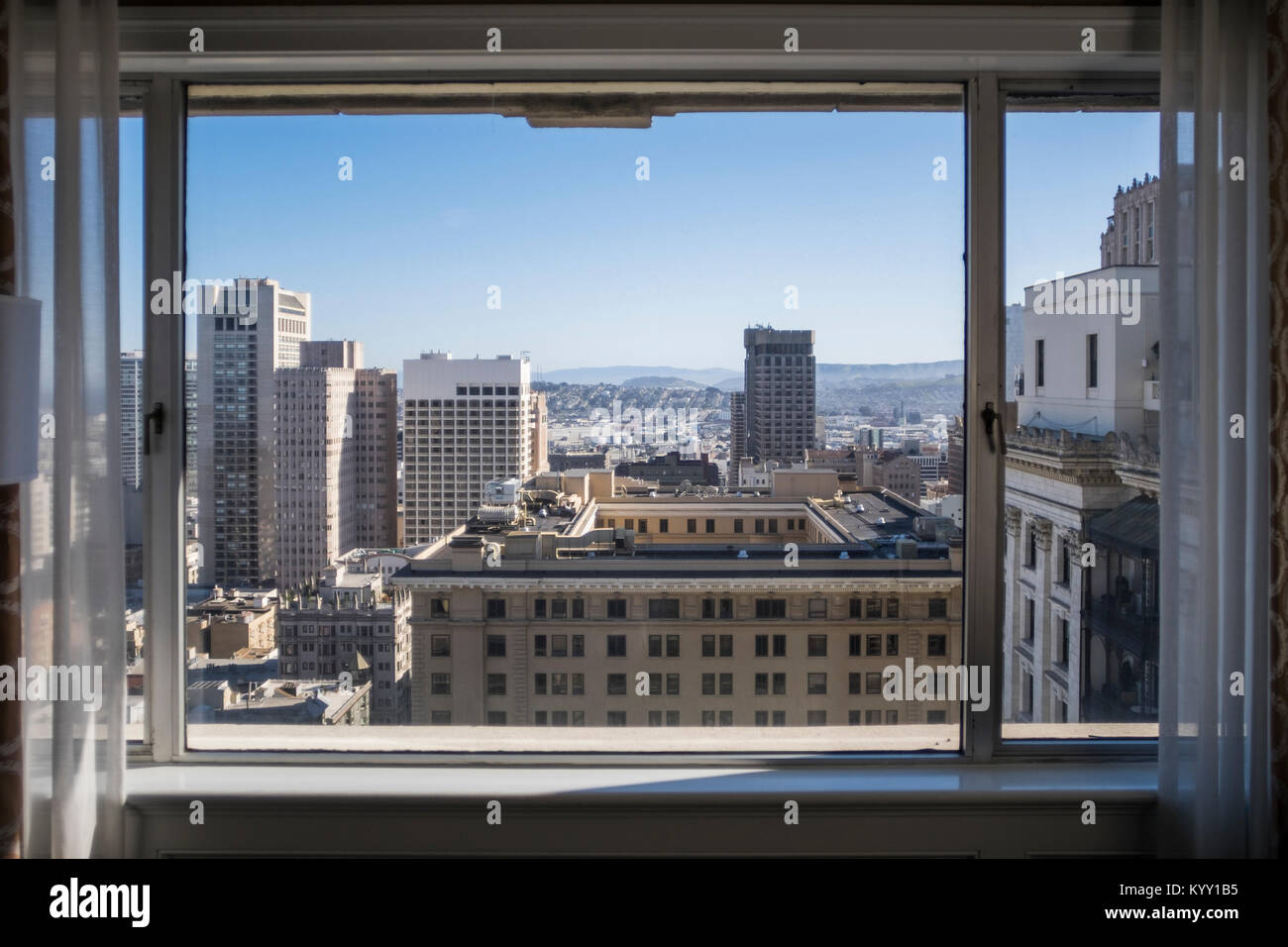 Buildings in city against sky seen through window Stock Photo - Alamy