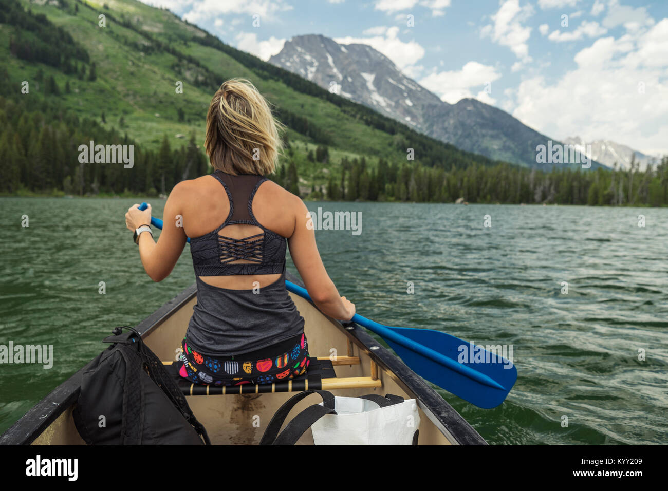 Woman rowing boat in river against mountains Stock Photo - Alamy