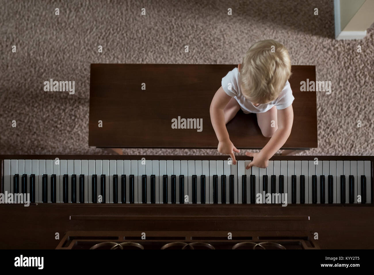 Overhead view of boy playing piano at home Stock Photo - Alamy