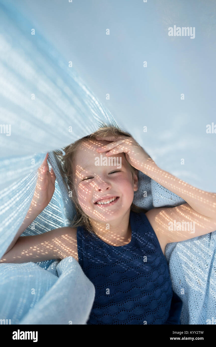 Cheerful girl playing under blanket Stock Photo - Alamy