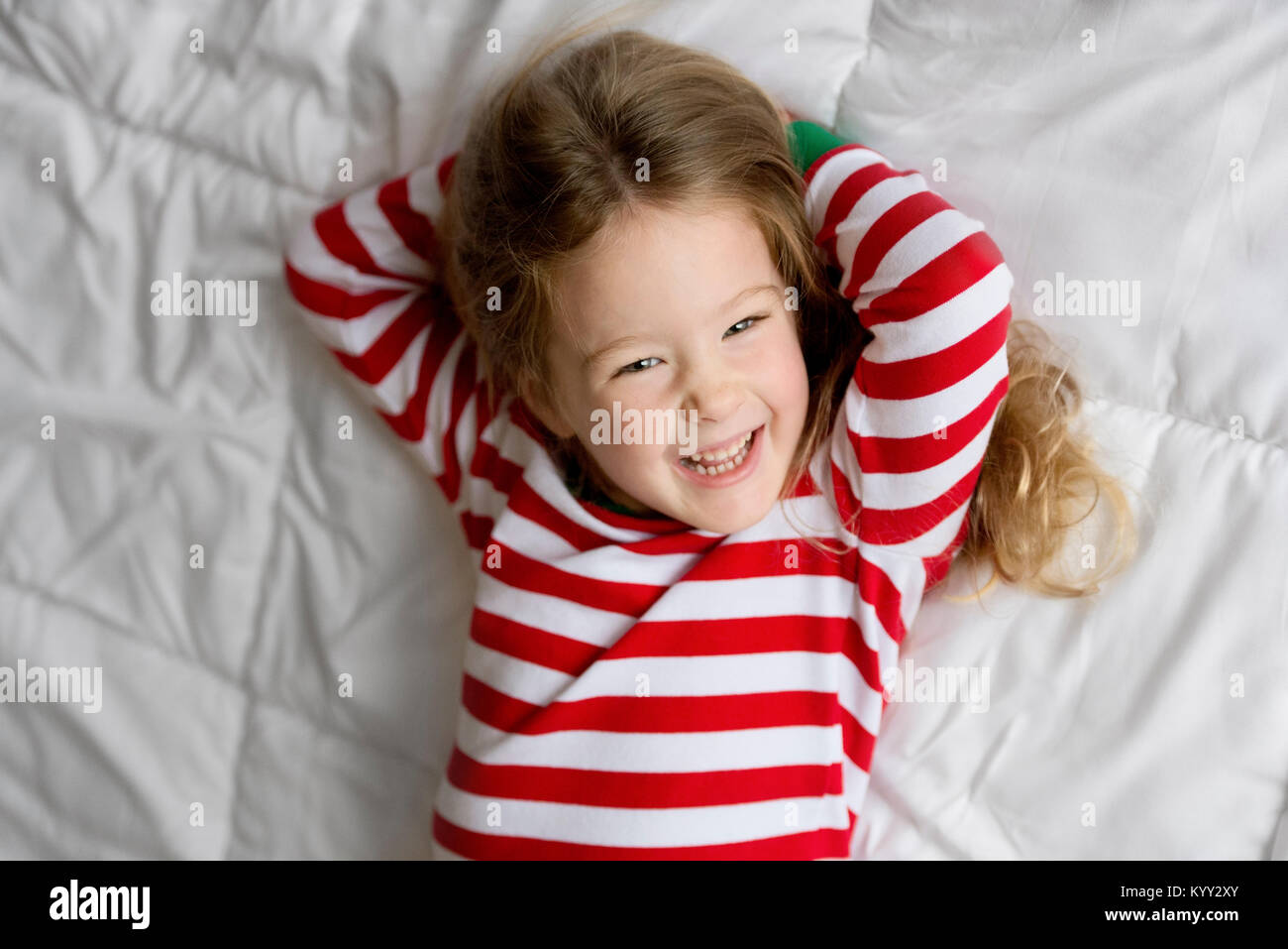 Overhead portrait of smiling girl lying on bed during christmas Stock Photo - Alamy
