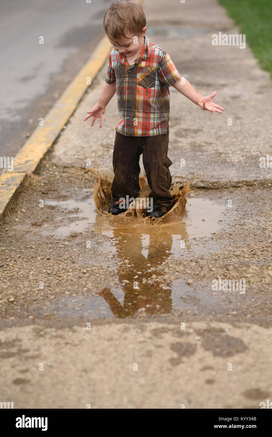 Boy jumping in puddle hi-res stock photography and images - Alamy