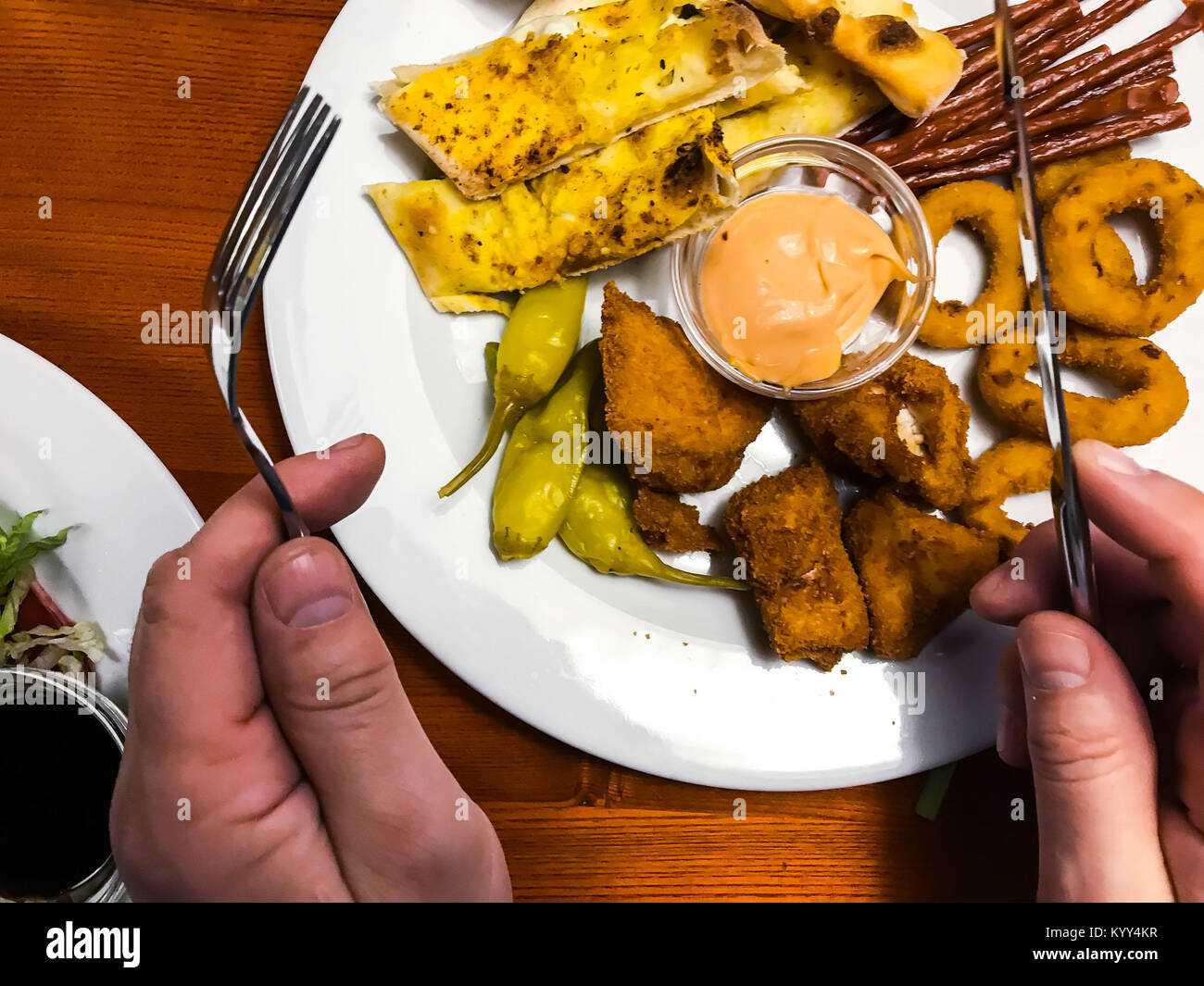 Plate with snacks on the table, men's hands. Studio photo Stock Photo ...