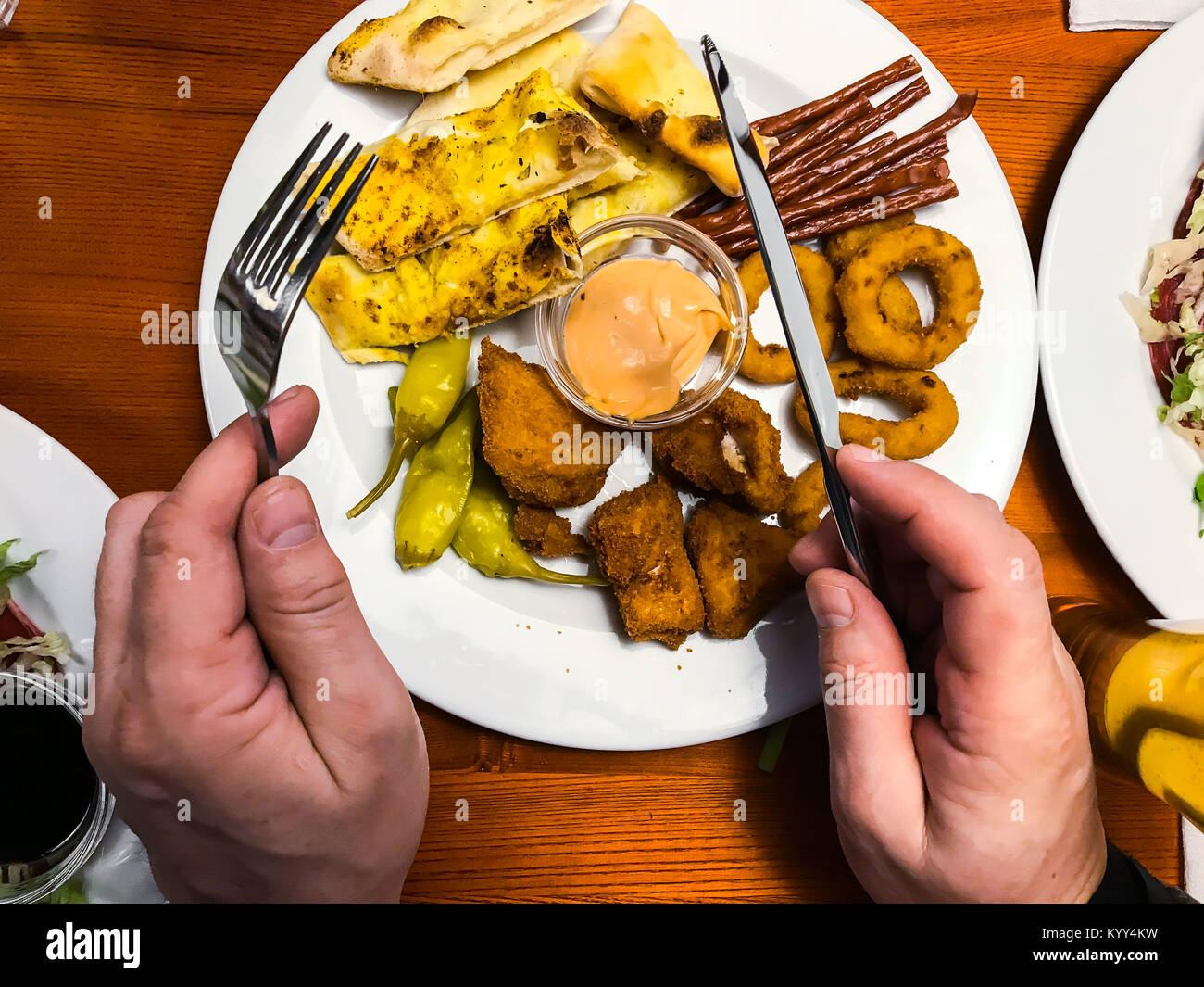 Plate with snacks on the table, men's hands. Studio photo Stock Photo ...