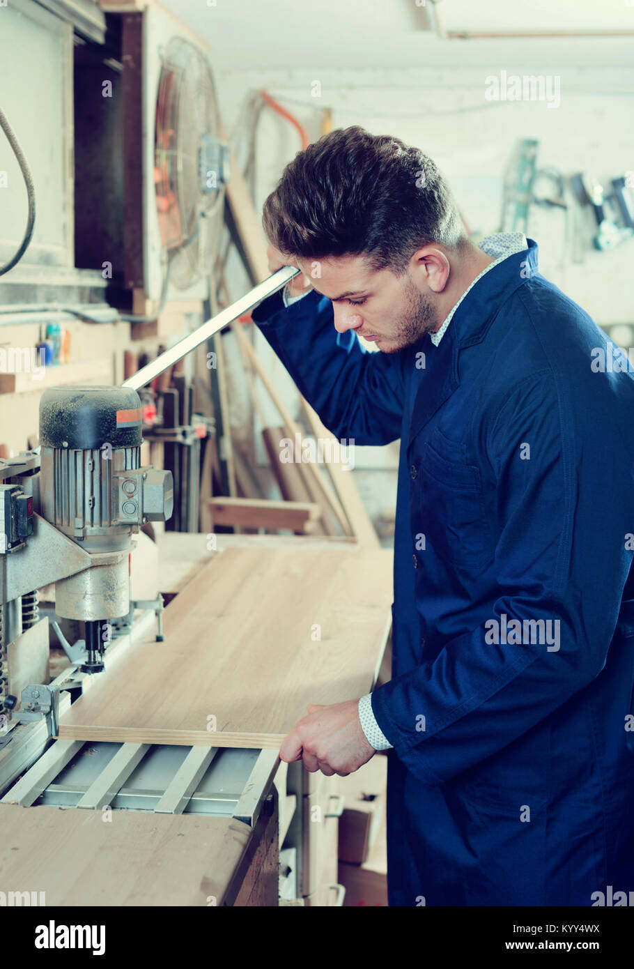 Smiling working man preparing chipboard for work at a workshop Stock ...