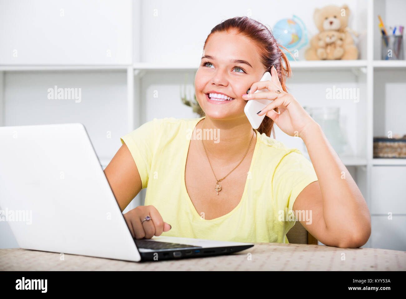 happy smiling female teenager student chatting on phone and typing on ...