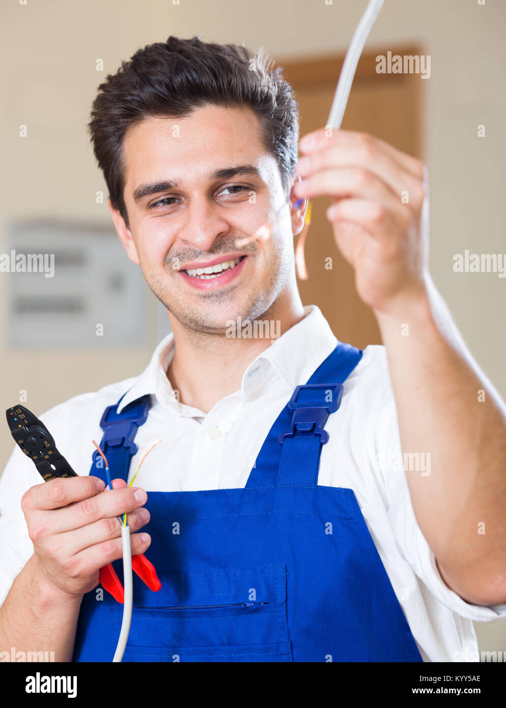 Young professional fixing indoor wiring in new building Stock Photo - Alamy