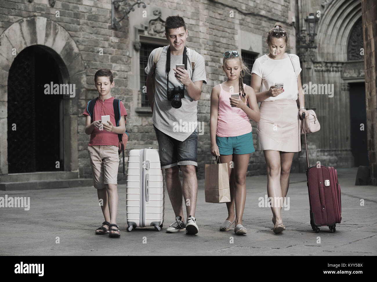 Glad tourist family with two kids busying with phones during walk Stock ...