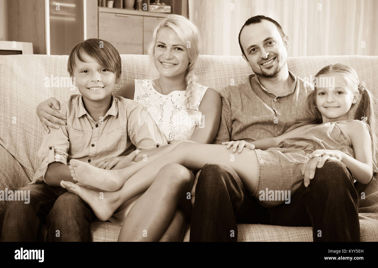 Portrait of smiling middle class family with two children at home ...