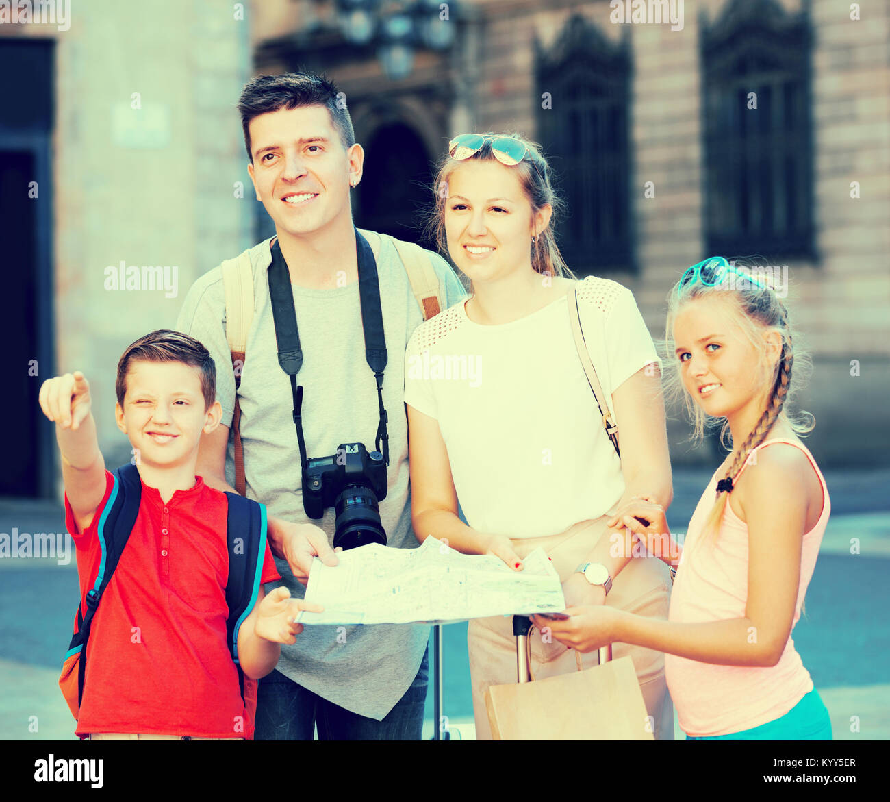 Young family tourist of four visiting sights of European city with map ...