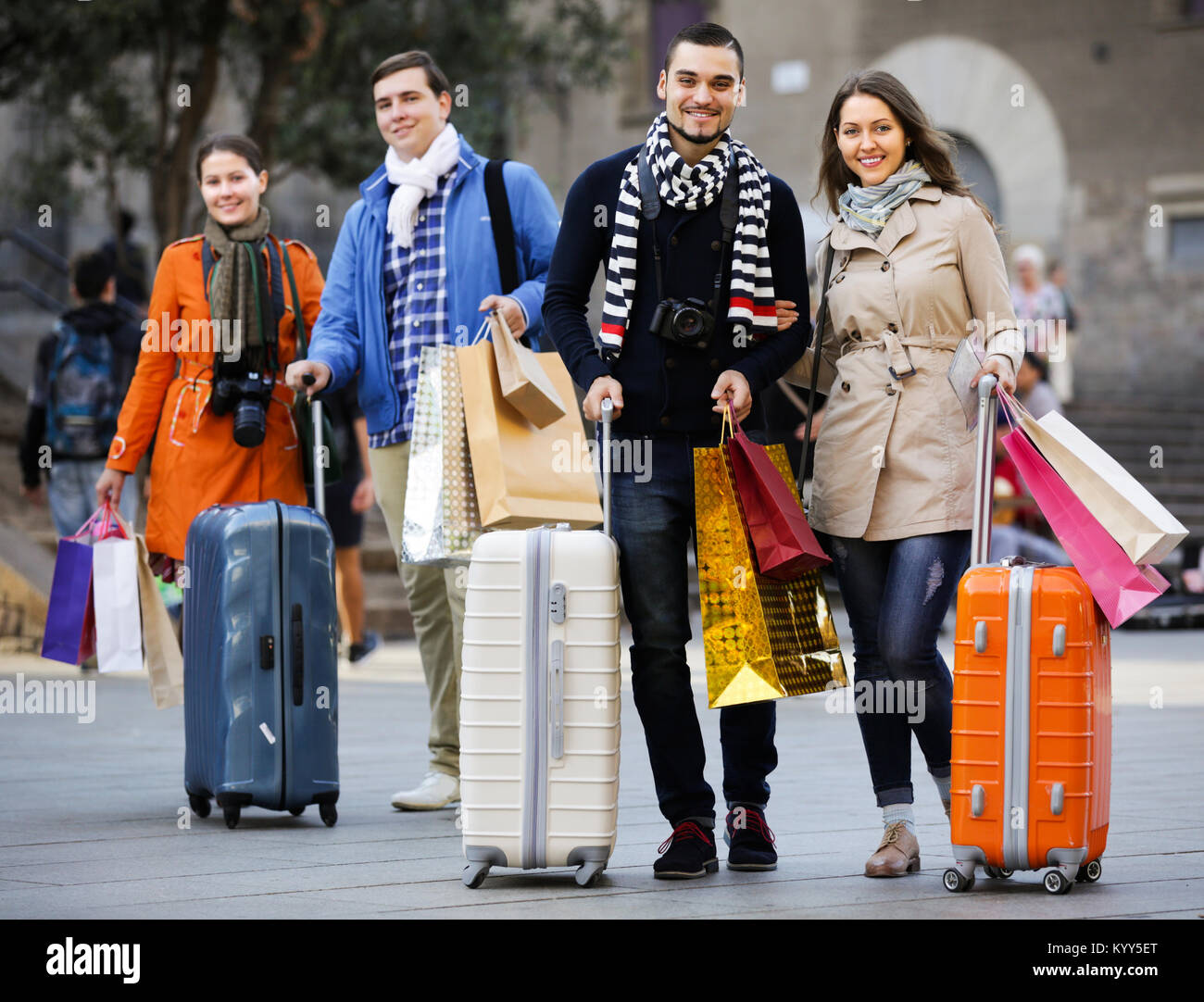 Happy young adults friends chasing streets in shopping tour Stock Photo ...