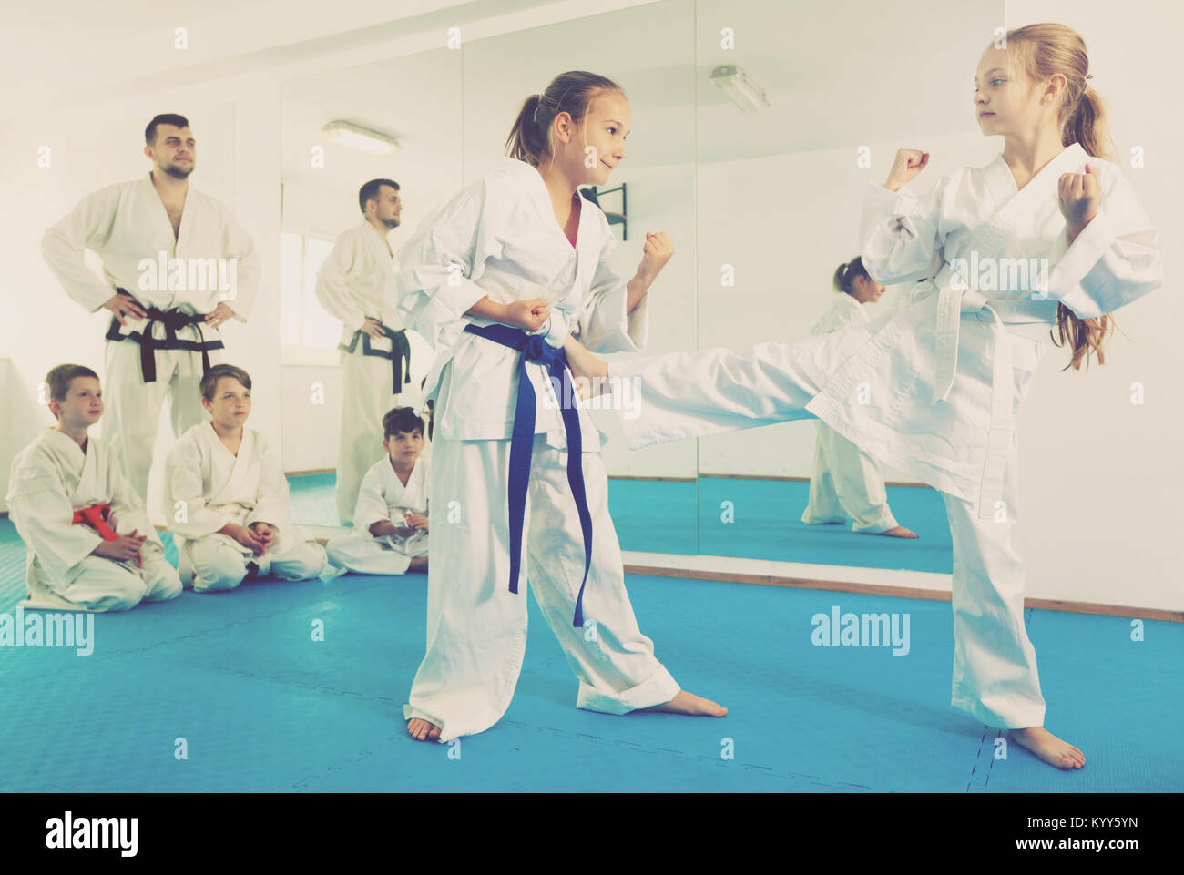Happy pair of little girls practicing new karate moves during class ...