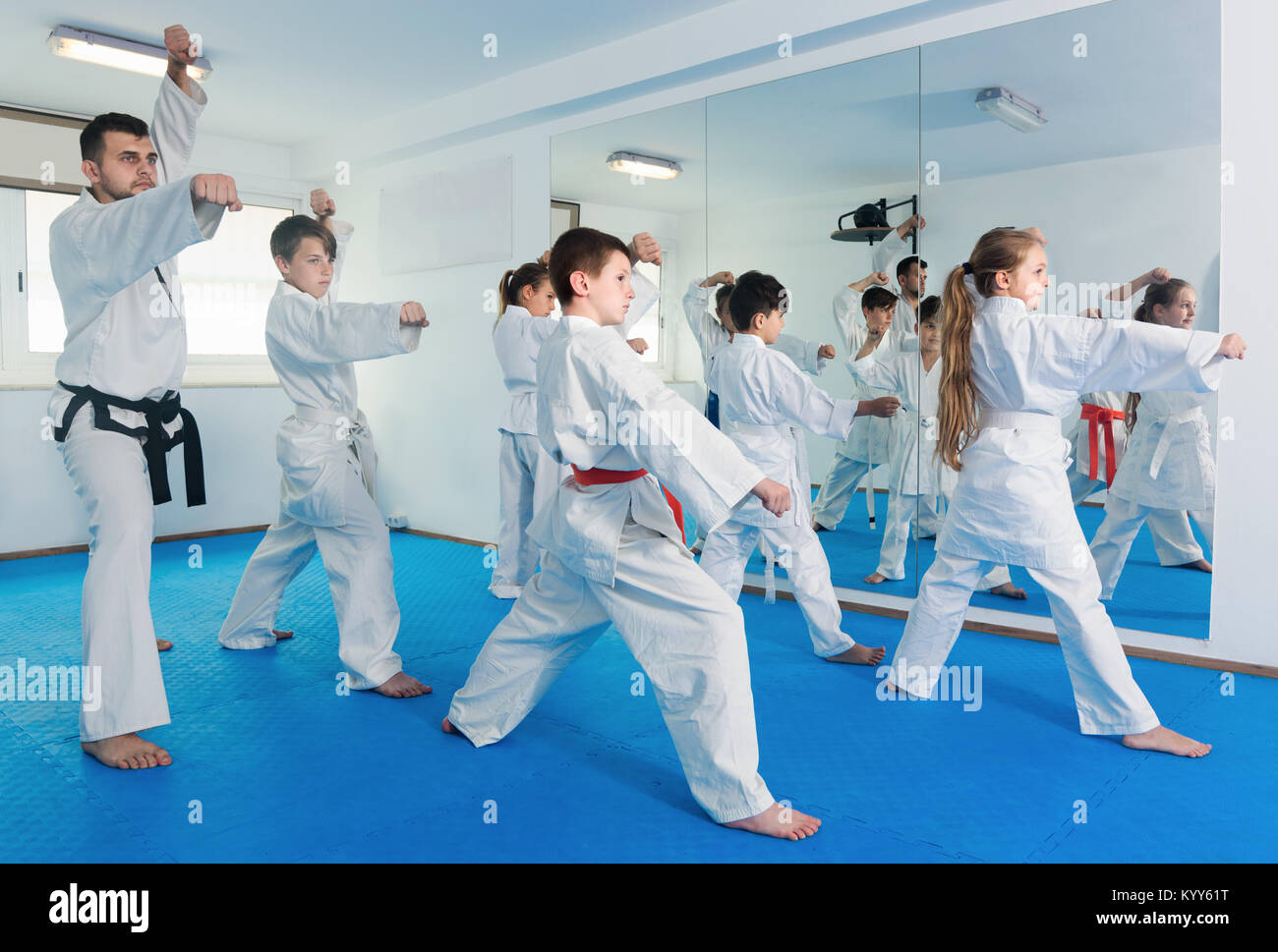 Group of teenagers trying a new moves with master during karate class ...
