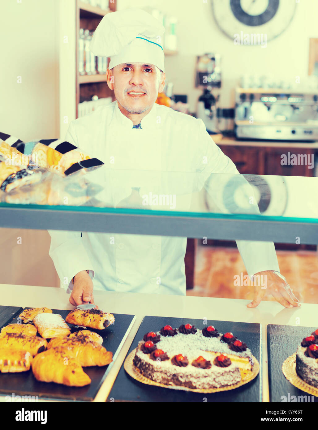 Baker man is offering tasty cakes, rolls and pies in bakery Stock Photo ...