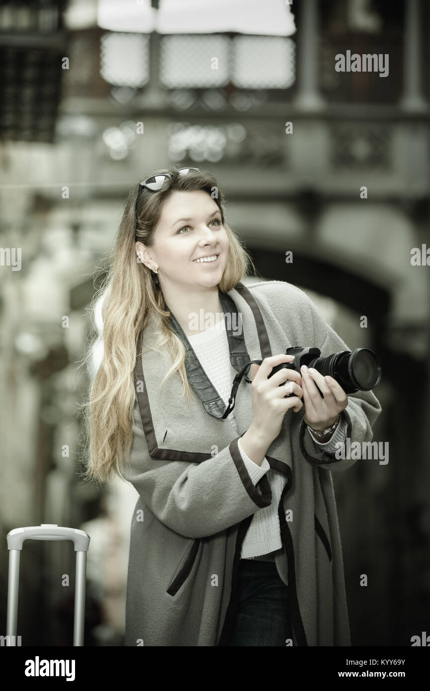 Young happy cheerful woman looking curious and taking a pictures ...