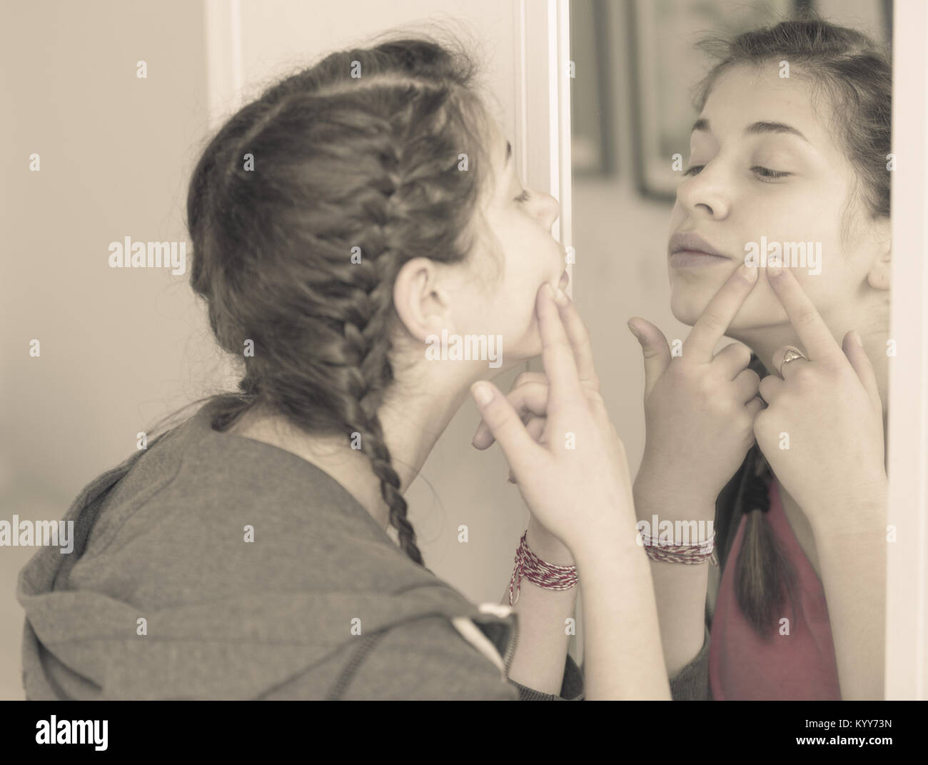 Female teenager squeezing acne spots alone at home Stock Photo - Alamy